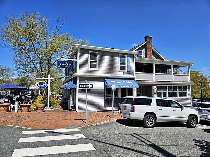 The welcoming blue awnings and vibrant potted plants make Blue Cafe's exterior as inviting as a friend's porch on a perfect summer day.