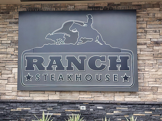 The modern stone facade of Ranch Steakhouse stands confidently against the Oklahoma sky, like a culinary fortress promising delicious treasures within.