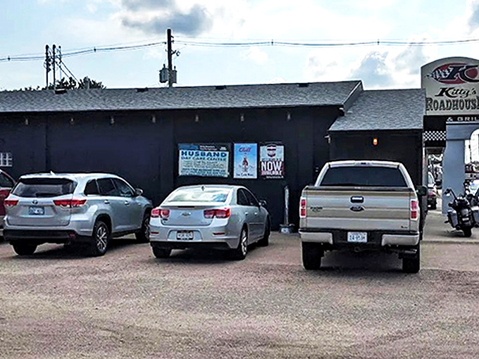 The unassuming black exterior of Kitty's Roadhouse stands like a culinary oasis in Hastings, promising roadside delights that Nebraska locals have treasured for years.