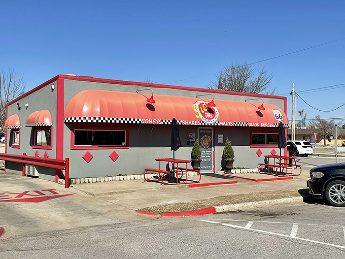 The classic Route 66 signage and vibrant red awning of Sid's Diner beckon hungry travelers like a neon-lit oasis in the Oklahoma landscape.
