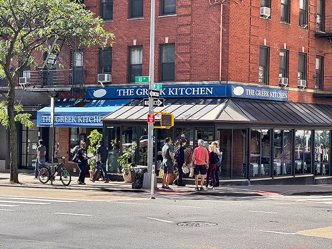 The blue awning of The Greek Kitchen beckons like a Mediterranean oasis amid Manhattan's brick landscape. Your Aegean adventure awaits!