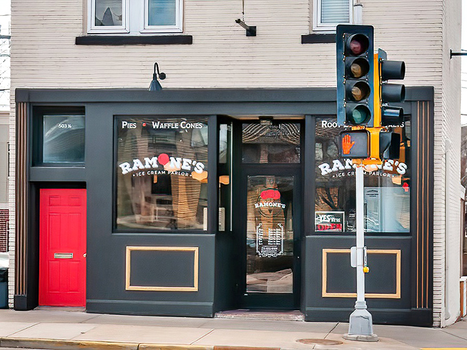 The classic black storefront with that striking red door is like finding the entrance to Willy Wonka's factory hiding in plain sight on a Wisconsin street corner.