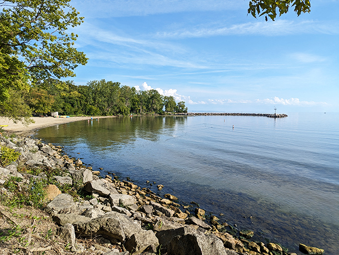 Twilight transforms Lake Erie into a moody masterpiece. Standing on that tree stump feels like being the captain of your own island adventure.