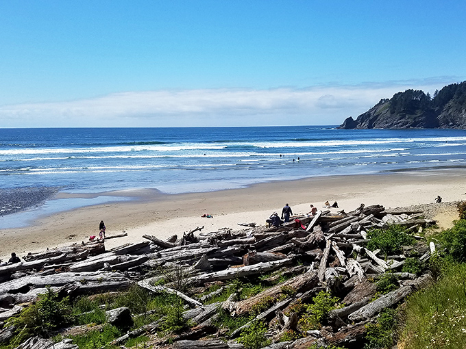 Golden sands meet dramatic cliffs where surfers catch perfect waves beneath an impossibly blue Oregon sky. Mother Nature showing off again.