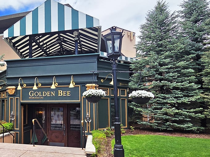 The emerald jewel of Colorado Springs beckons with its distinctive green and white awning, promising British comfort in the shadow of the Rockies.