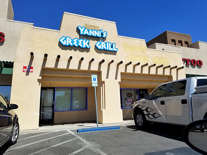 The unassuming exterior of Yanni's Greek Grill stands like a Mediterranean mirage in the Las Vegas desert, promising authentic flavors behind its blue signage.