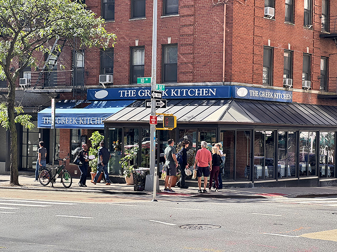 The blue awning of The Greek Kitchen beckons like a Mediterranean oasis amid Manhattan's brick landscape. Your Aegean adventure awaits!