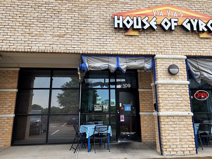The glowing sign of Yia Yia's House of Gyros beckons like a Mediterranean lighthouse in a sea of Texas strip malls. Greek paradise awaits inside!