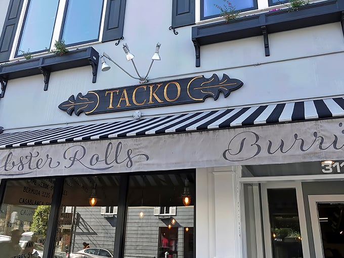 The iconic Tacko storefront proudly announces its dual culinary citizenship with "Tacos," "Lobster Rolls," and "Burritos" emblazoned on its cheerful awning.
