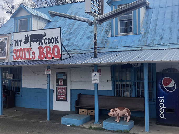 The pilgrimage destination itself: Scott's Bar-B-Que stands proudly with its metal roof and blue-trimmed exterior, a humble temple to smoked meat perfection.
