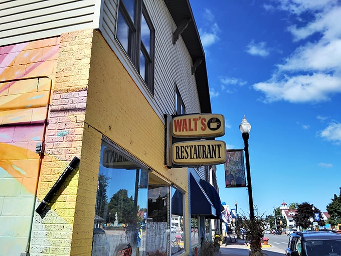 The unassuming yellow brick exterior of Walt's Restaurant stands as a beacon of breakfast hope on Caseville's main street, promising comfort food and local charm.