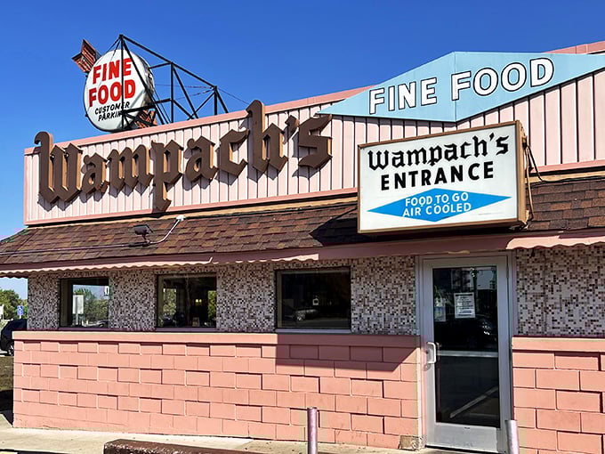 The pink brick facade of Wampach's stands like a time capsule, promising "FINE FOOD" with the confidence of someone who's been keeping that promise for decades.