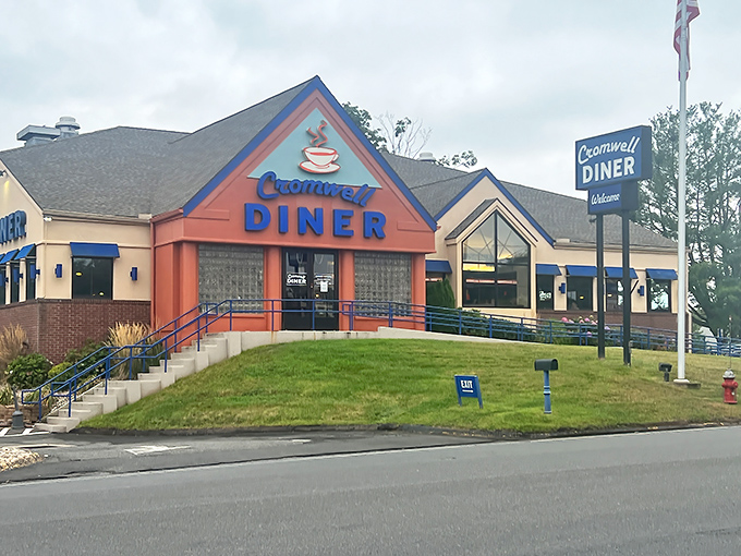 The Cromwell Diner's distinctive blue and orange exterior welcomes hungry travelers like a lighthouse beacon for breakfast enthusiasts navigating the sea of morning hunger.