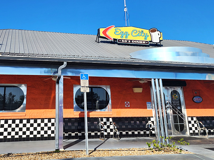 The vibrant orange exterior with its classic checkered trim isn't just eye-catching&mdash;it's a beacon of breakfast hope for hungry travelers on Florida's highways.