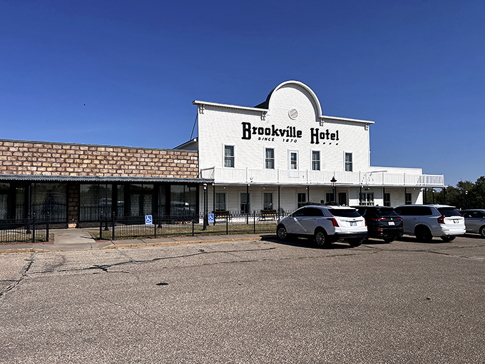 The iconic white facade of Brookville Hotel stands proudly against the Kansas sky, a beacon for fried chicken pilgrims from across the Midwest.