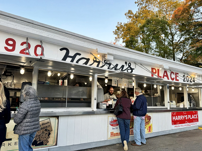 The white facade of Harry's Place stands like a culinary lighthouse, beckoning hungry travelers with its iconic red lettering and promise of roadside bliss. 