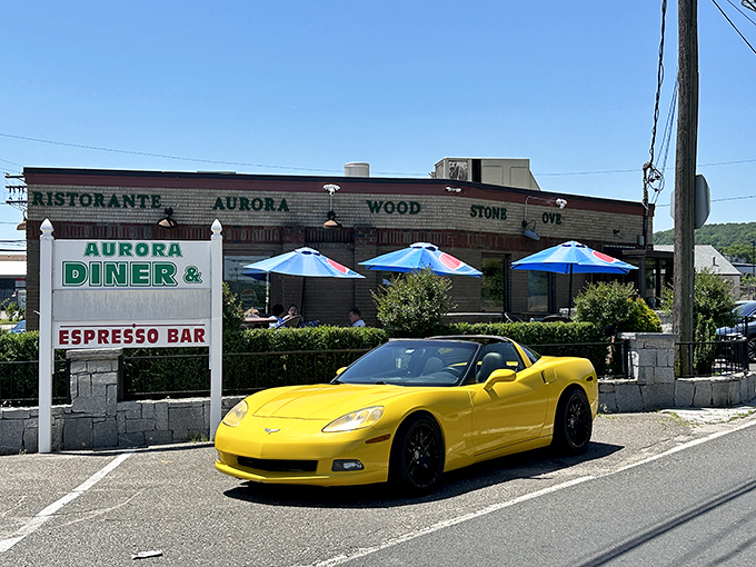 The classic roadside charm of Aurora Diner beckons hungry travelers with its promise of comfort food and that unmistakable blue-umbrella welcome.
