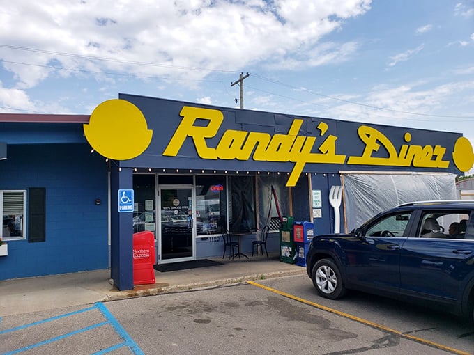 The iconic navy blue exterior with bright yellow lettering announces Randy's Diner like a beacon for breakfast lovers. That giant fork on the wall? It's pointing you toward hash brown nirvana.