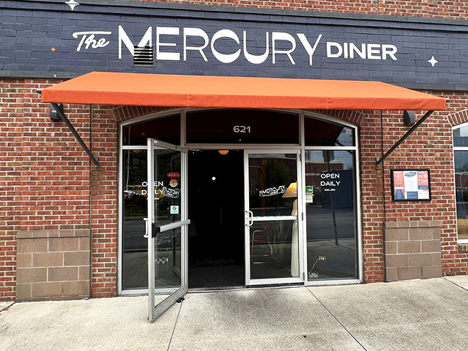 The Mercury Diner's navy blue facade with bright orange awning isn't just inviting—it's practically a bat signal for hungry Ohioans seeking comfort food nirvana.