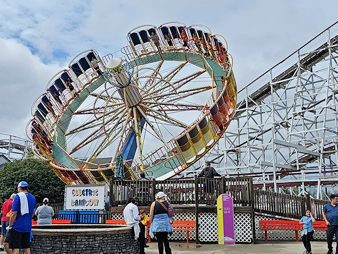 The classic Scrambler ride spins against a backdrop of wooden coaster tracks &ndash; a perfect snapshot of old-school amusement park magic that never goes out of style.