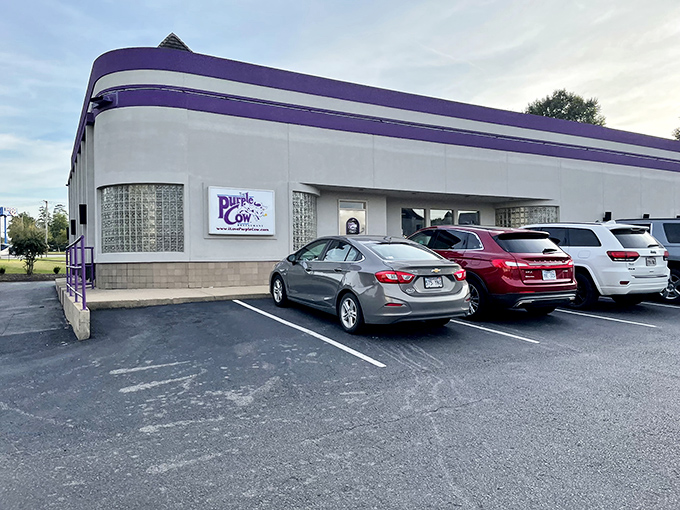 The streamlined Art Deco exterior of The Purple Cow stands like a time machine to the 1950s, promising nostalgic delights within its crisp white walls.