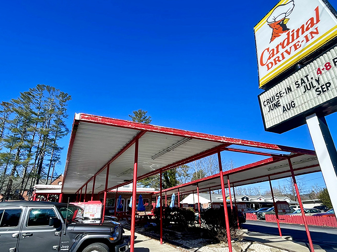 The iconic Cardinal Drive-In sign stands tall against the Carolina blue sky, beckoning hungry travelers with its retro charm and promise of comfort food paradise.