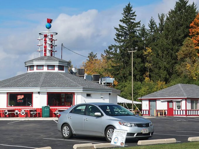 The unmistakable silhouette of Wayne's Drive-In stands against a perfect Wisconsin sky, its iconic neon sign promising burger bliss to all who approach.
