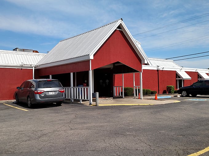 The iconic red barn exterior of Brangus Steakhouse stands out against the Arkansas sky like a beacon for hungry travelers seeking serious steak satisfaction.