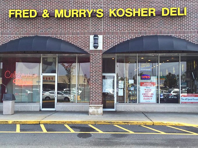 The Promised Land of pastrami sits quietly in a strip mall, its yellow sign a beacon to hungry souls seeking deli salvation.