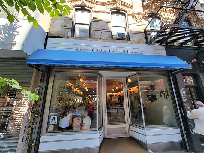 The iconic blue awning of Russ & Daughters Cafe stands out like a culinary lighthouse, guiding hungry souls to this Lower East Side institution.
