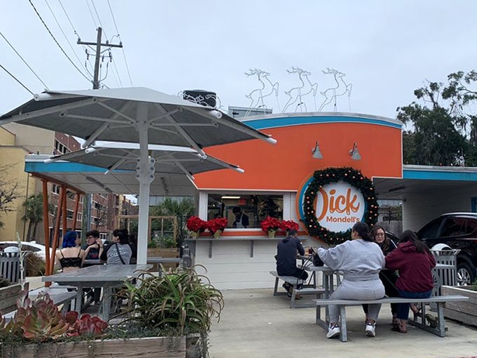 The bright orange and turquoise exterior isn't just eye-catching&mdash;it's a siren call to burger lovers everywhere. Florida sunshine and shade umbrellas complete the perfect dining setup.