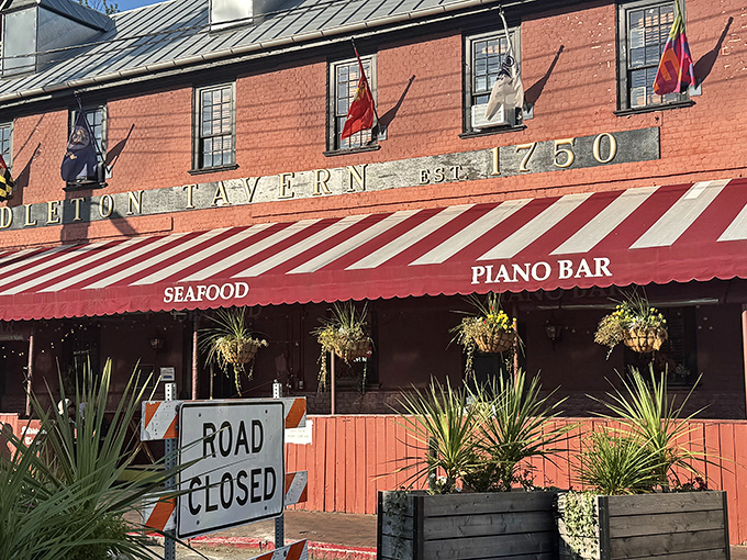 The historic red brick facade of Middleton Tavern stands proudly since 1750, its striped awning beckoning like a culinary time machine to colonial Annapolis.