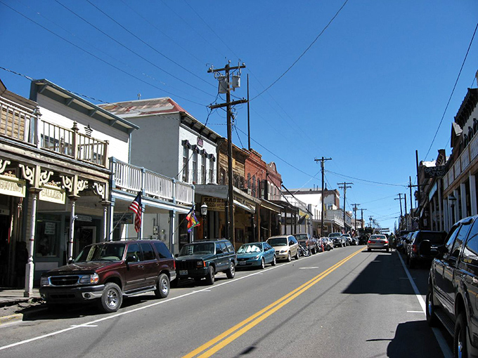 C Street stretches before you like a living museum, where Victorian-era buildings stand shoulder to shoulder under Nevada's impossibly blue sky.