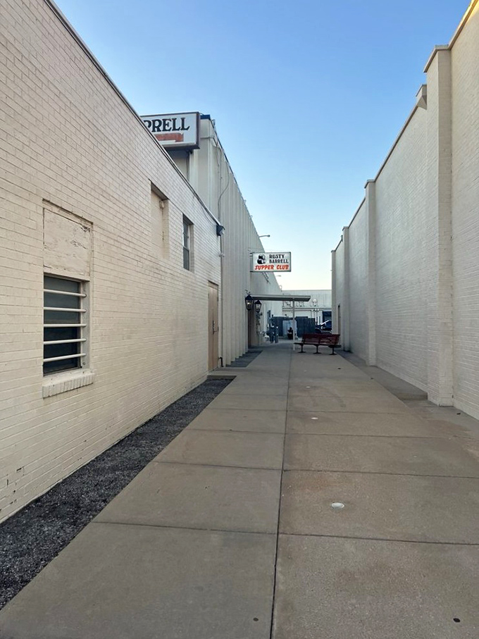The unassuming entrance to Rusty Barrell Supper Club proves the old adage: never judge a steak by its storefront. That red bench? Your waiting room to carnivore heaven.