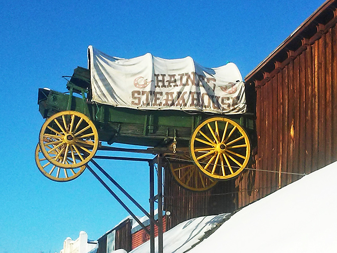 The wagon on the roof isn't just decoration &ndash; it's a beacon for hungry travelers. This rustic wooden exterior promises authentic Western dining experiences inside.