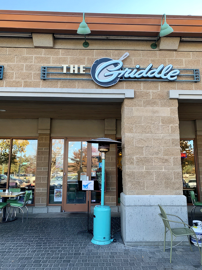 The stylish exterior of The Griddle beckons with its warm stone facade and signature blue lamps&mdash;breakfast paradise hiding in plain sight.
