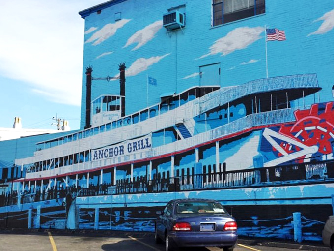 The blue-painted exterior of Anchor Grill features a stunning steamboat mural that's like a maritime welcome committee for hungry travelers.