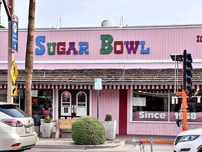 The iconic pink facade of Sugar Bowl stands as a sweet beacon in Old Town Scottsdale, its colorful lettering promising frozen happiness inside.