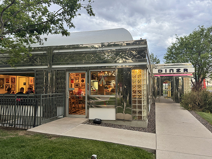 That neon sign doesn't whisper&mdash;it announces with retro swagger: "Hungry humans, your comfort food paradise awaits!" The turquoise and red color scheme practically sings against the Colorado sky.