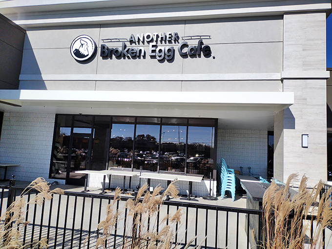 The modern facade of Another Broken Egg Cafe welcomes hungry patrons with its signature teal patio furniture&mdash;a breakfast beacon in Prairie Village.