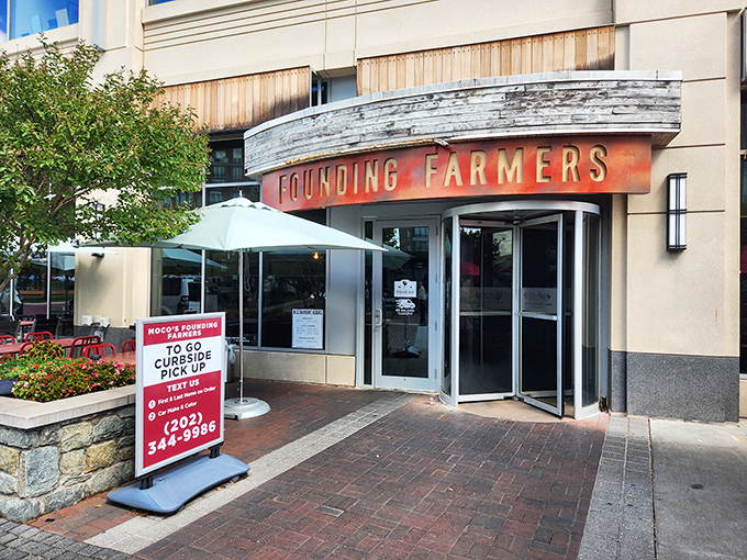 The unassuming entrance to flavor paradise. Founding Farmers' modest exterior in Potomac gives zero hints about the culinary fireworks waiting inside.