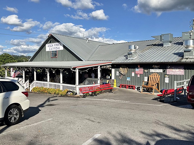 The unassuming exterior of Huck Finn's Catfish stands like a humble guardian of flavor, promising Southern comfort beneath its metal roof and welcoming porch.