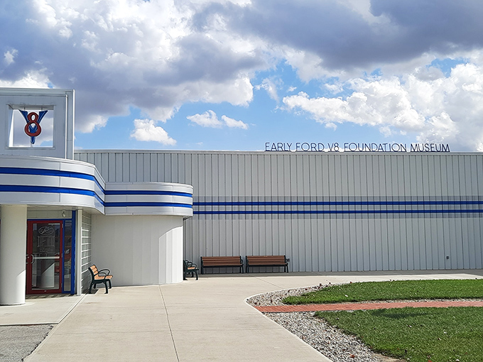 A gleaming 1936 Ford sedan poses like a silver screen starlet against the museum's distinctive white architecture. Automotive time travel at its finest.