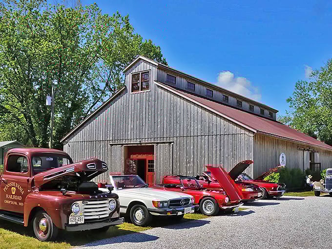The Classic Motor Museum's weathered barn exterior houses automotive treasures inside, while a cherry-red Alfa Romeo Spider teases what awaits curious visitors.