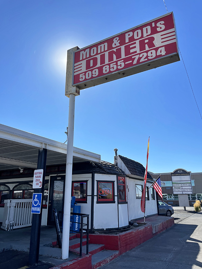 The classic red and white sign beckons like a lighthouse for hungry travelers. Mom and Pop's Diner isn't just a place&mdash;it's a promise of comfort ahead.