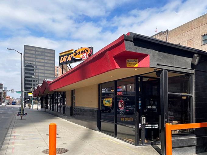 Sam's No. 3 stands proudly with its iconic red awning, a beacon of comfort food amid downtown Denver's glass skyscrapers. Classic diner meets modern city.