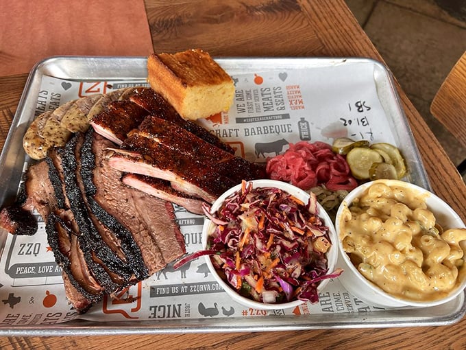 A metal tray holding what might be the perfect meal&mdash;smoked meats in their prime alongside cornbread that deserves its own appreciation society.