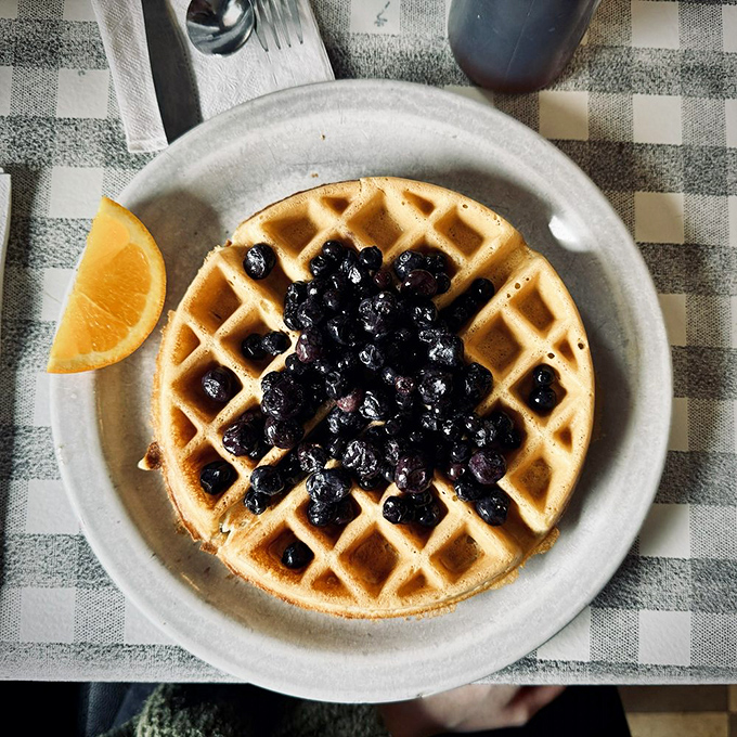 A Belgian waffle that serves as the perfect foundation for a mountain of blueberries. Breakfast architecture at its most delicious.