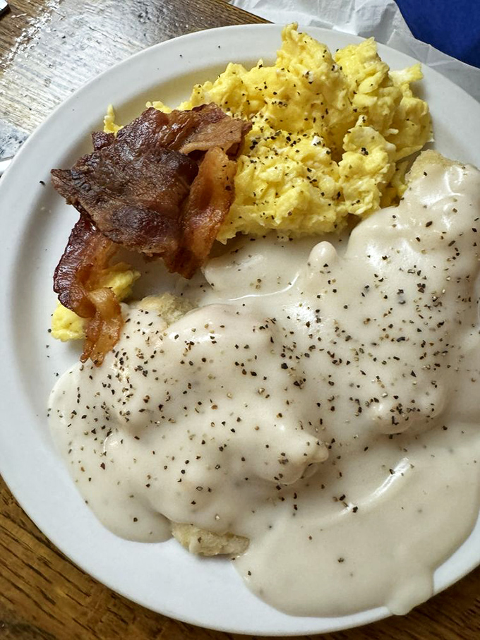 Biscuits drowning happily in a sea of pepper-speckled gravy. This plate is Southern comfort in its purest, most delicious form.