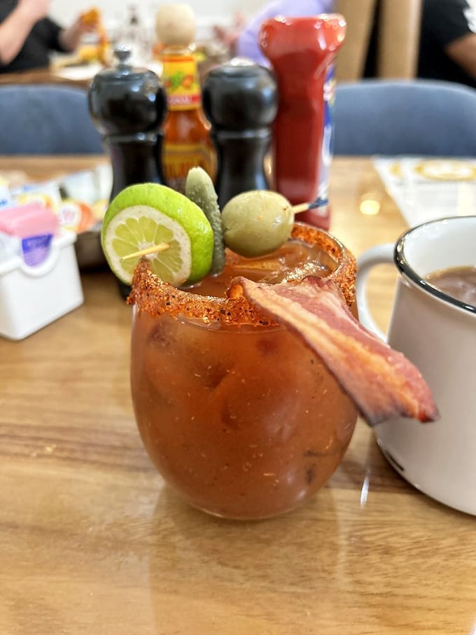 The Bloody Mary arrives garnished like it's trying to win a talent show&mdash;bacon strip, pickle, olive, and lime all competing for your attention.